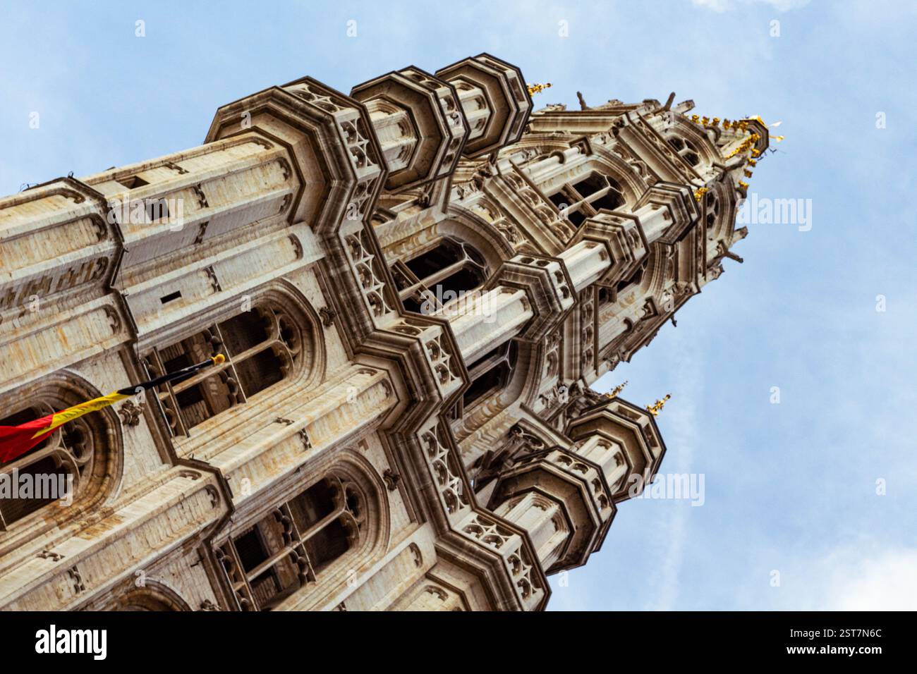 Brussels Town Hall tower at Grand Place, with a Belgian flag waving ...