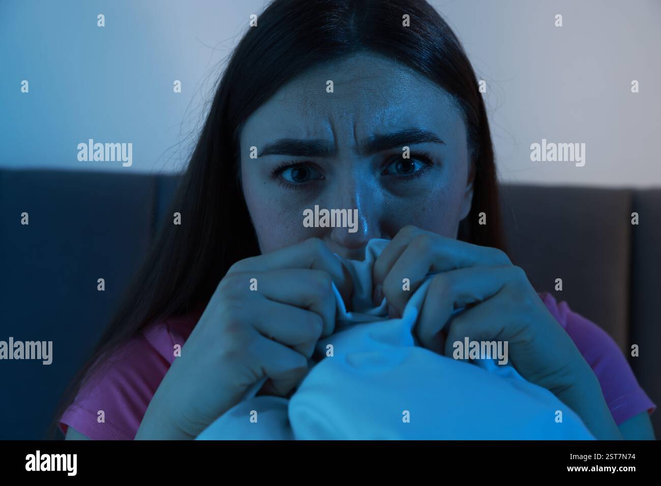 Fear of darkness. Scared young woman on bed in room at night Stock ...