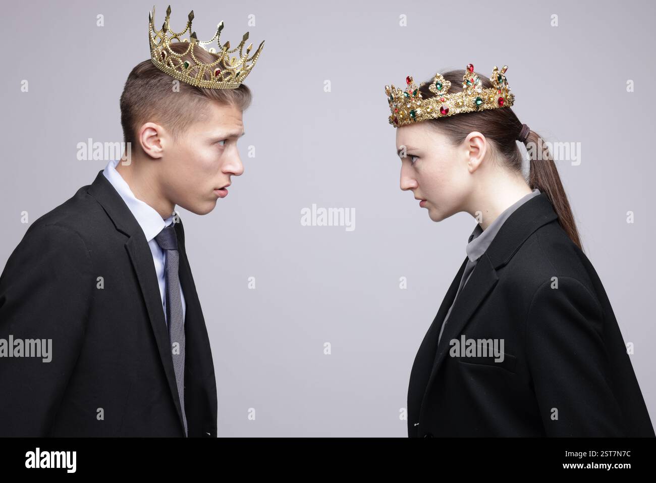 Business competition. Colleagues in golden crowns looking at each other ...