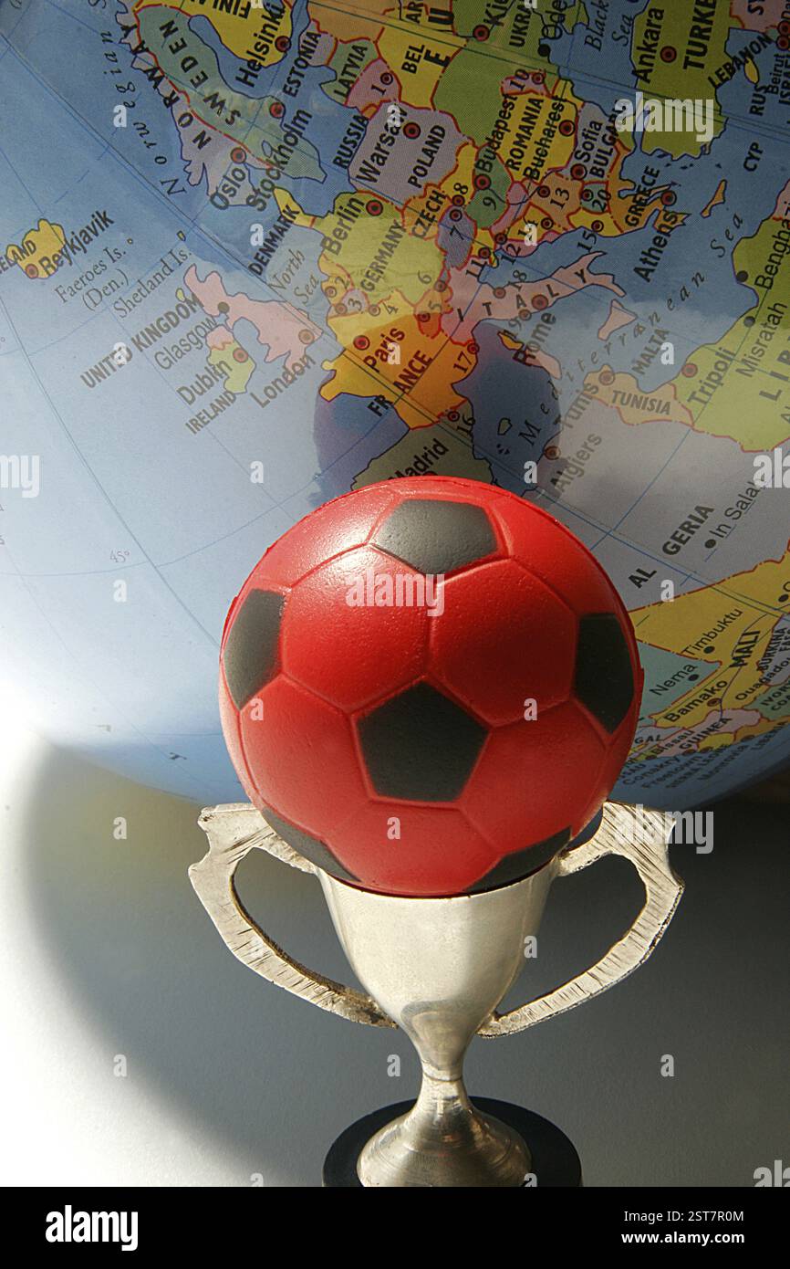 Small metal cup with red and black rubber ball of football sport and ...