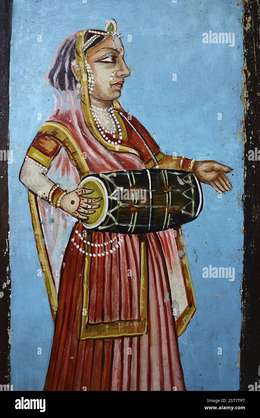 Woman playing Indian musical instrument Dholak, painting on the wall of ...