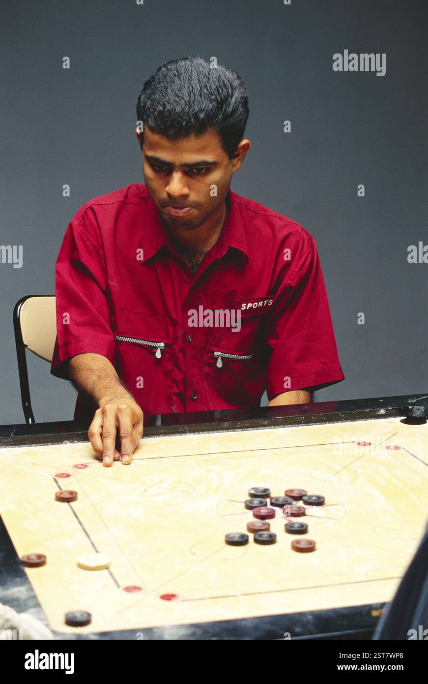Carom board player playing game Stock Photo - Alamy