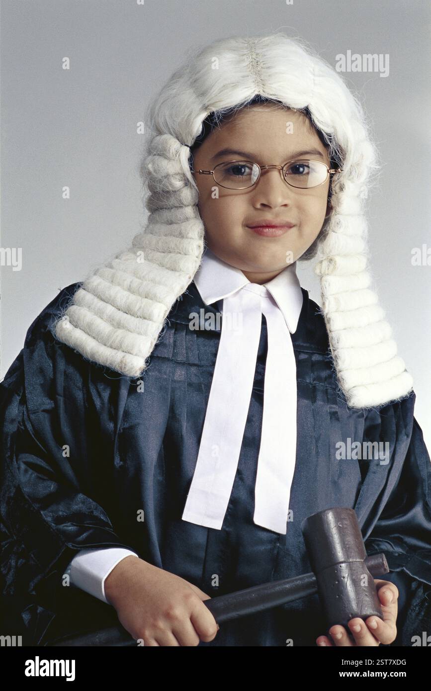 Child dressed as judge, boy wearing uniform and wig holding the baton ...