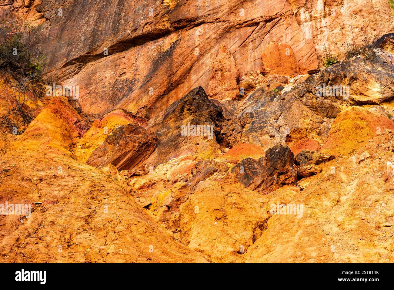 Eroded bauxite rock formation with bright orange colors in an abandoned ...