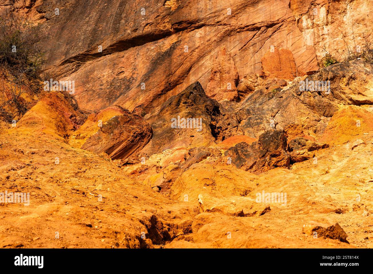 Eroded bauxite rock formation with bright orange colors in an abandoned ...