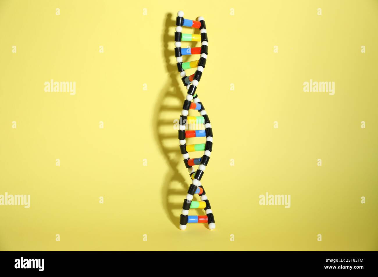 One DNA structure model on yellow background Stock Photo - Alamy