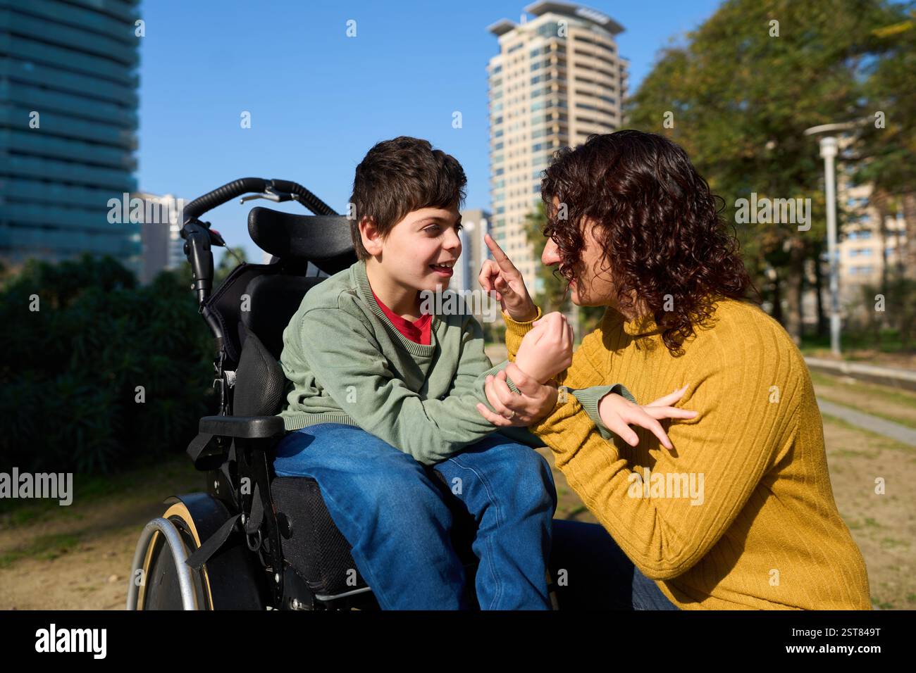 Happy child with disability communicating with special needs educator ...