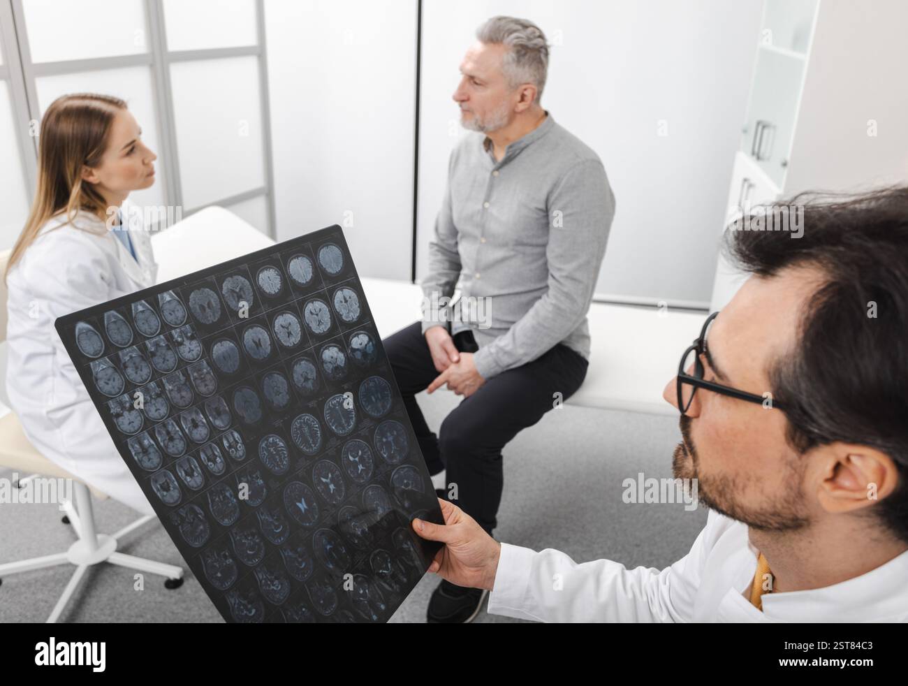 Doctor explaining to male patient results of MRI scan of his brain ...
