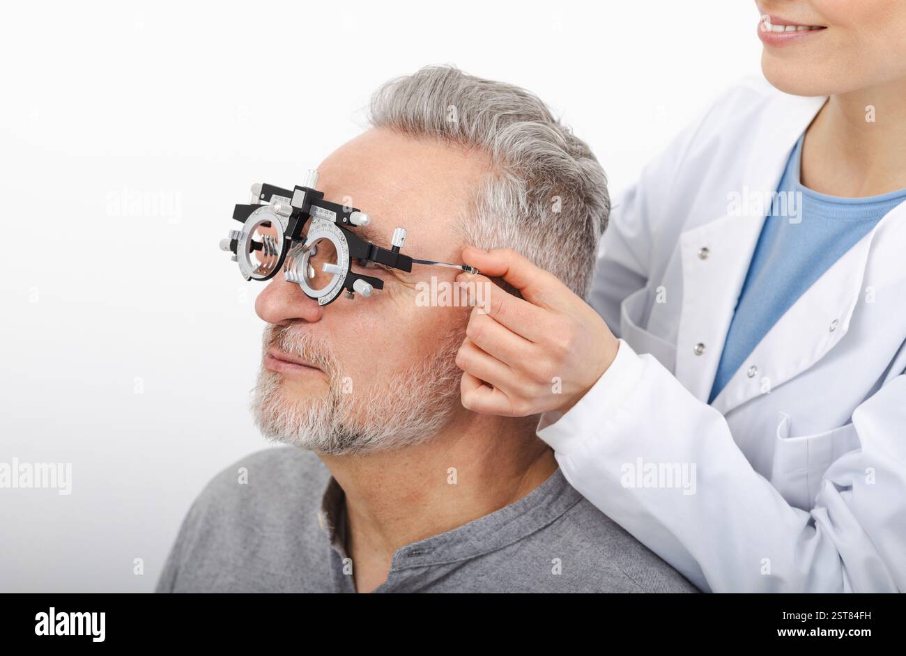 Ophthalmology. Optometrist selecting eyeglass lenses for senior man ...