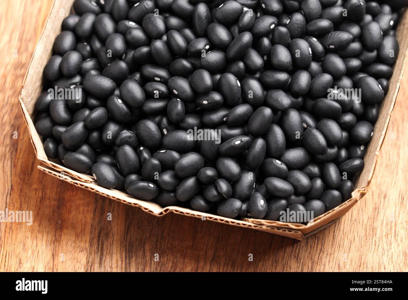 Organic black kidney beans in paper container on wooden table. Raw food ...