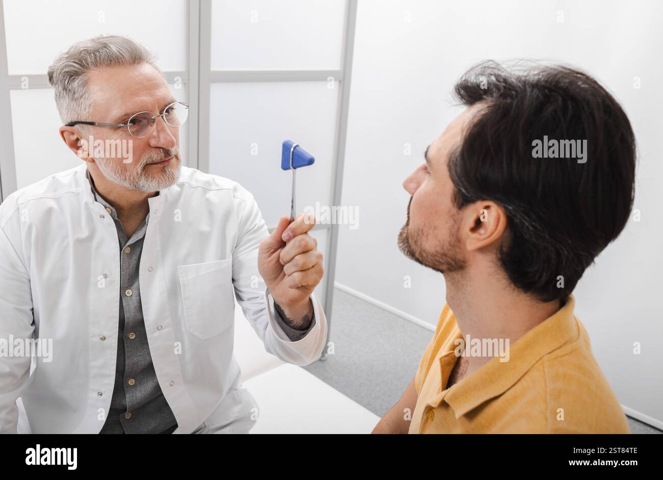 Doctor neurologist check-up male patient's nervous system and reflexes ...
