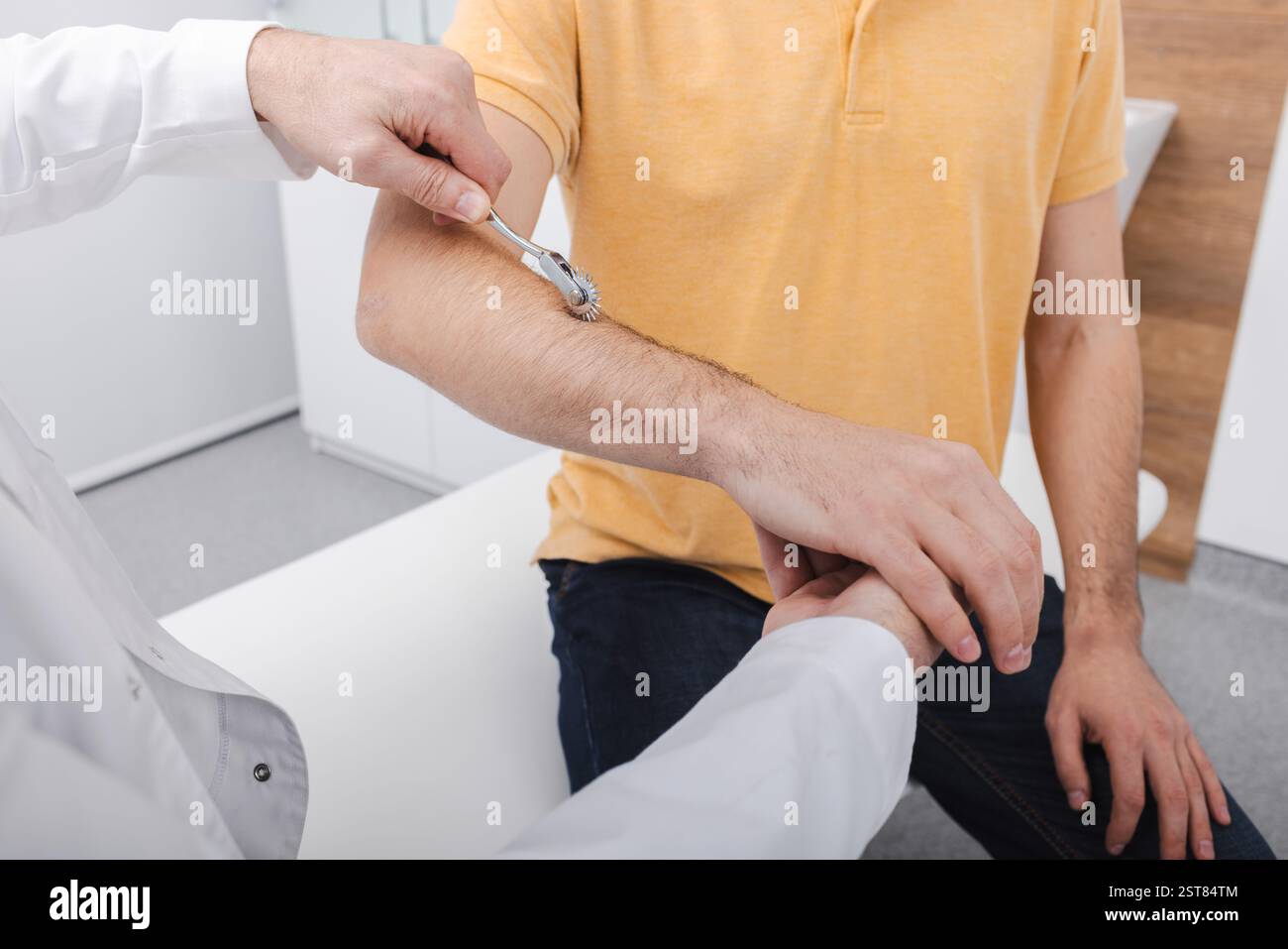 Neurology. Checking man hand reflexes using neurological needle wheel ...