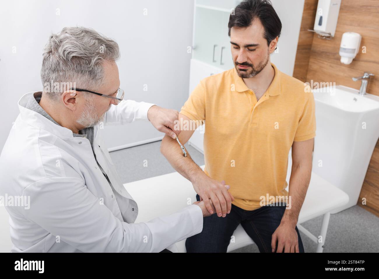 Neurology. Checking man hand reflexes using neurological needle wheel ...