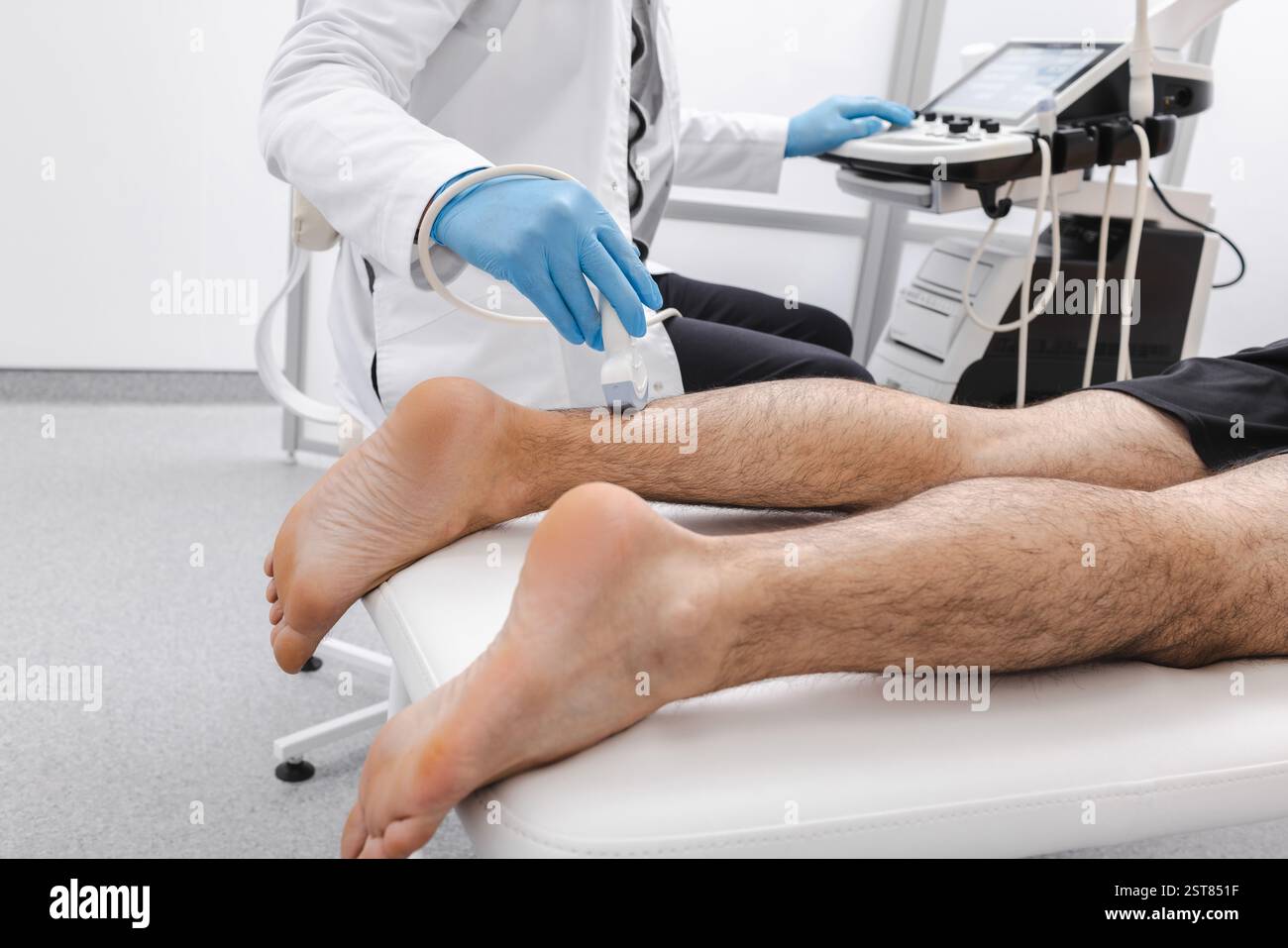 Ultrasonography of ankle joint. Adult man with leg injury undergoes ...