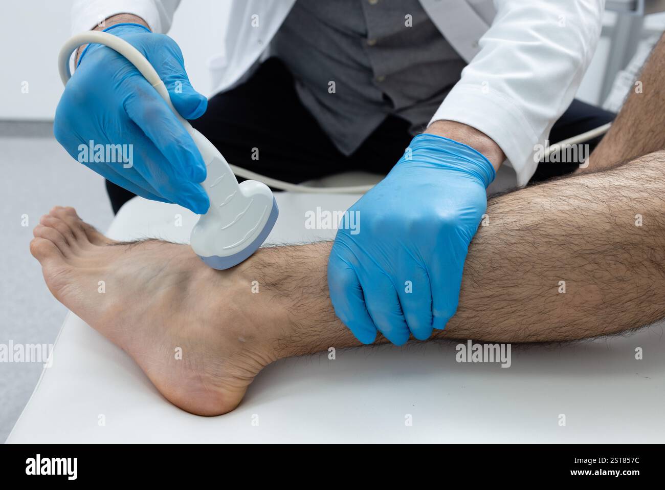 Diagnostic medical sonographer examines human ankle using high ...