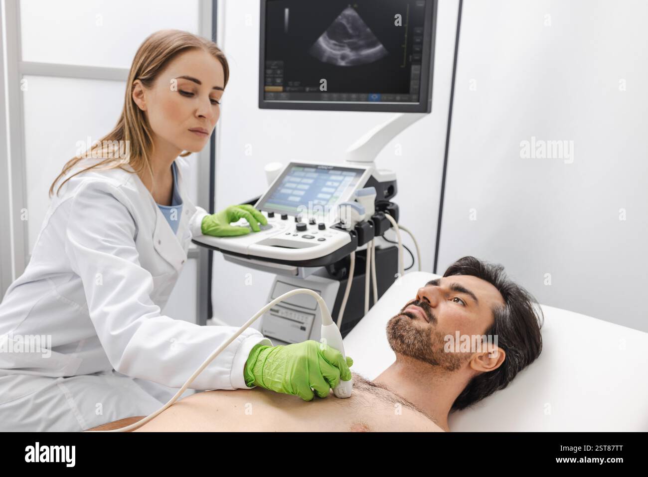 Heart ultrasound exam for adult man with ultrasound specialist while ...