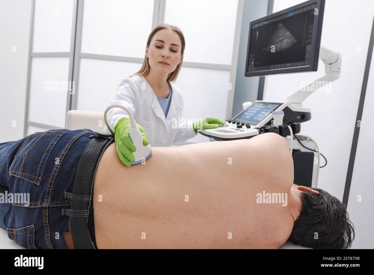 Male patient getting kidneys sonography exam lying on medical couch ...