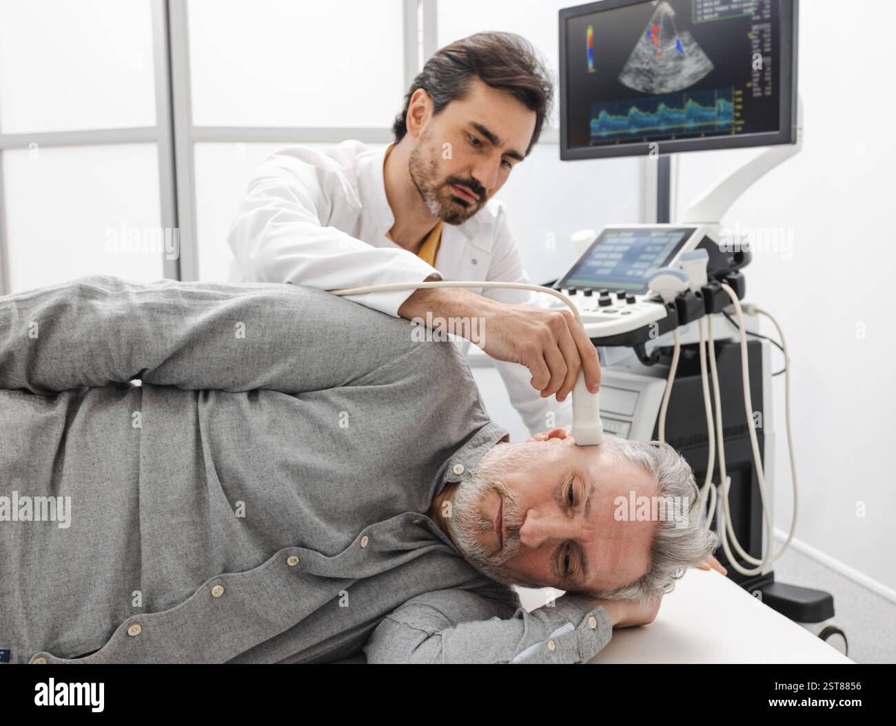 Sonographer examines brain of elderly man by placing ultrasound ...