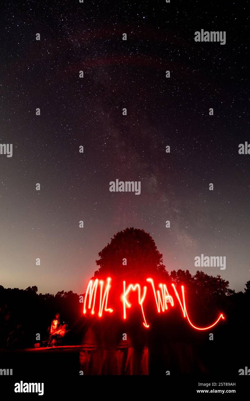 The Milky Way rises above a light-painted sign reading "milky way Stock ...