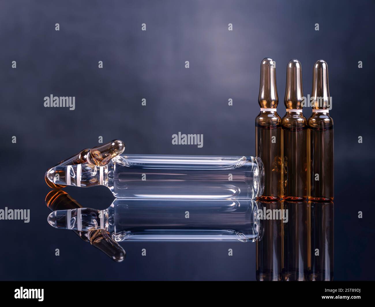Ampoules with medicine on glossy black background. Pharmaceutical ...