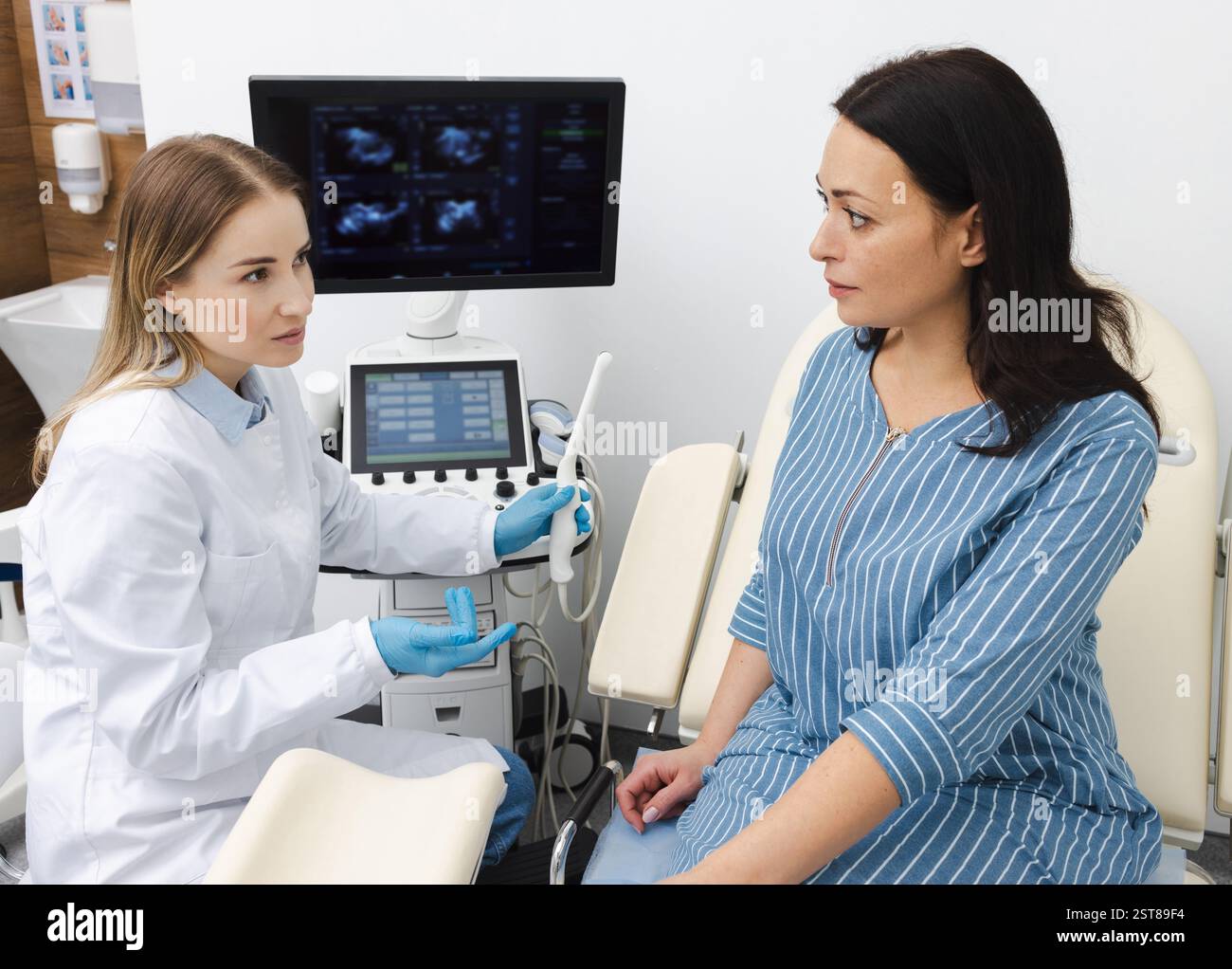 Doctor with ultrasound transvaginal sensor for ultrasound procedure to ...