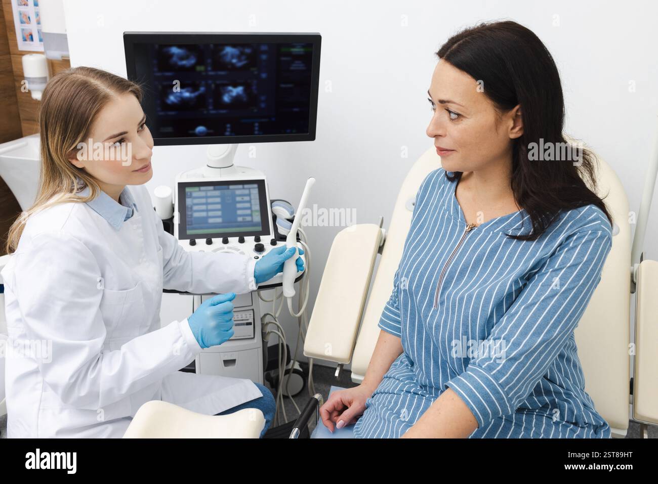 Woman patient during ovarian ultrasound exam in gynecology exam room ...