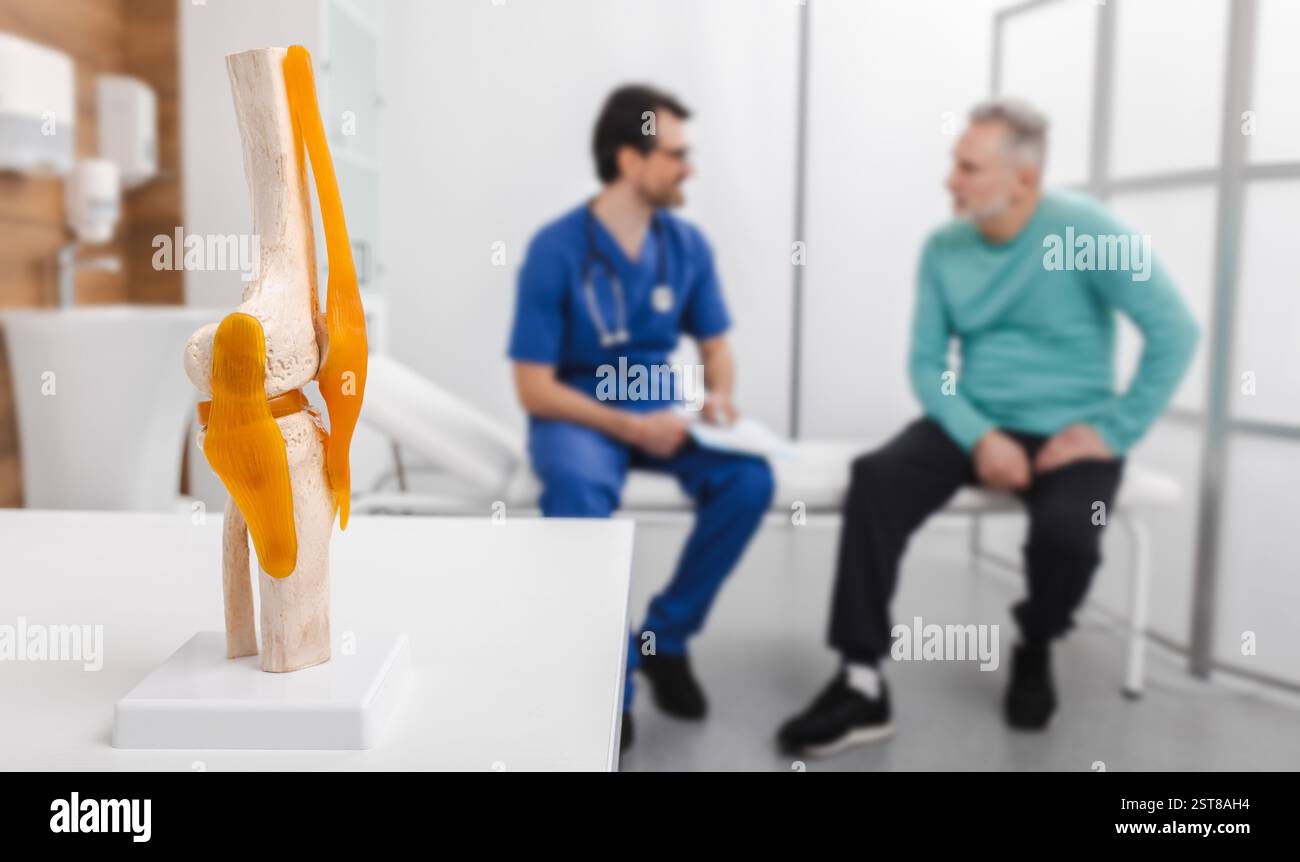 Senior man with knee injury during consultation with doctor ...