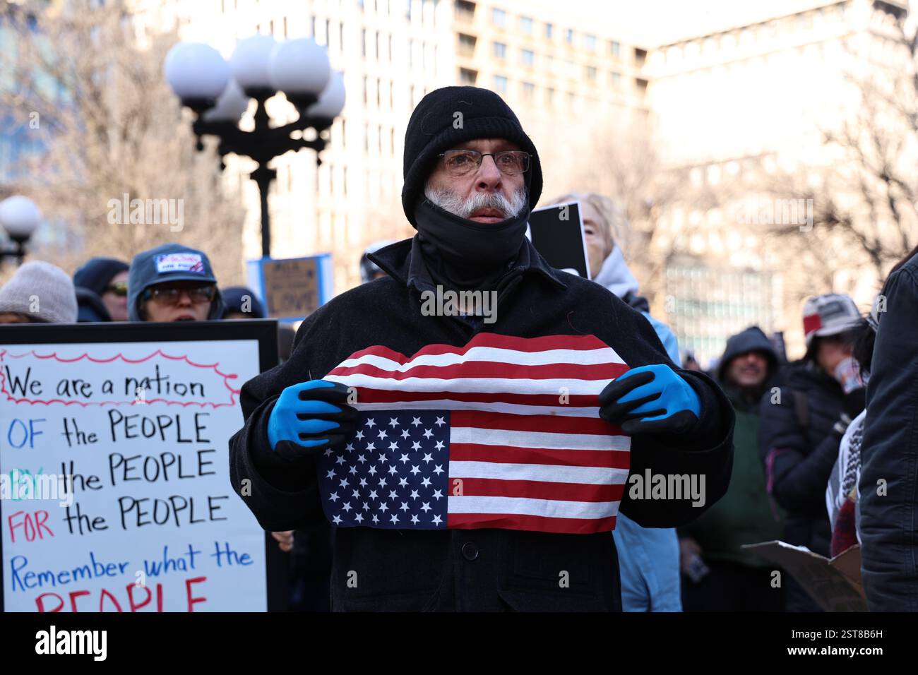 A man hold up a American flag upside down opposed to the policies of ...
