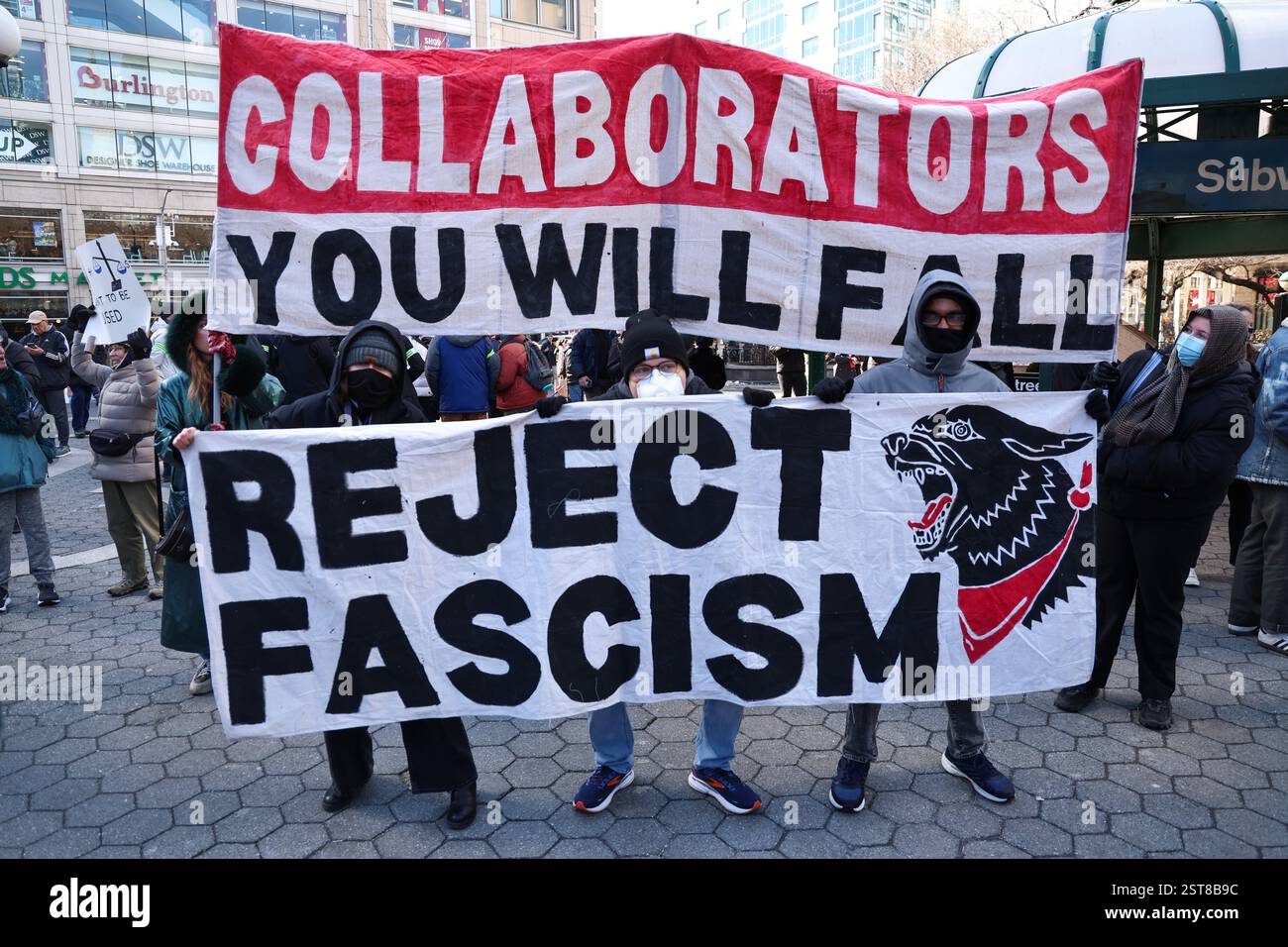 People hold up banners opposed to the policies of President Donald ...