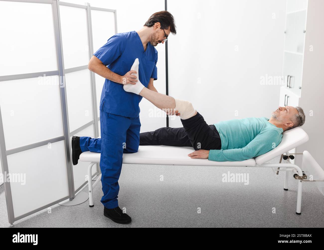 Healthcare professional conducts therapy on a patient's leg, focusing ...