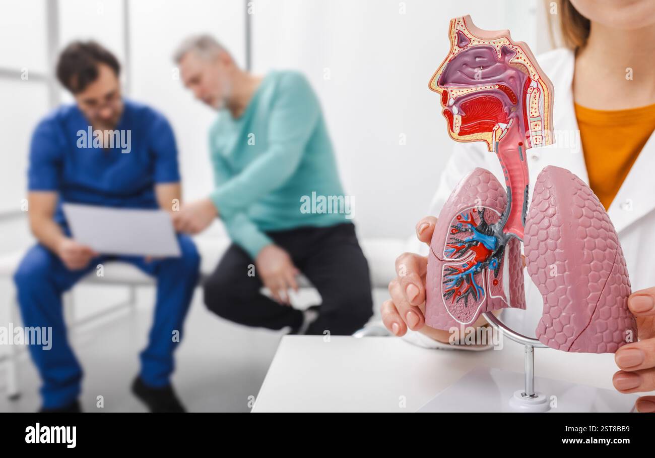 Specialist discusses lung health with a patient while showcasing a ...