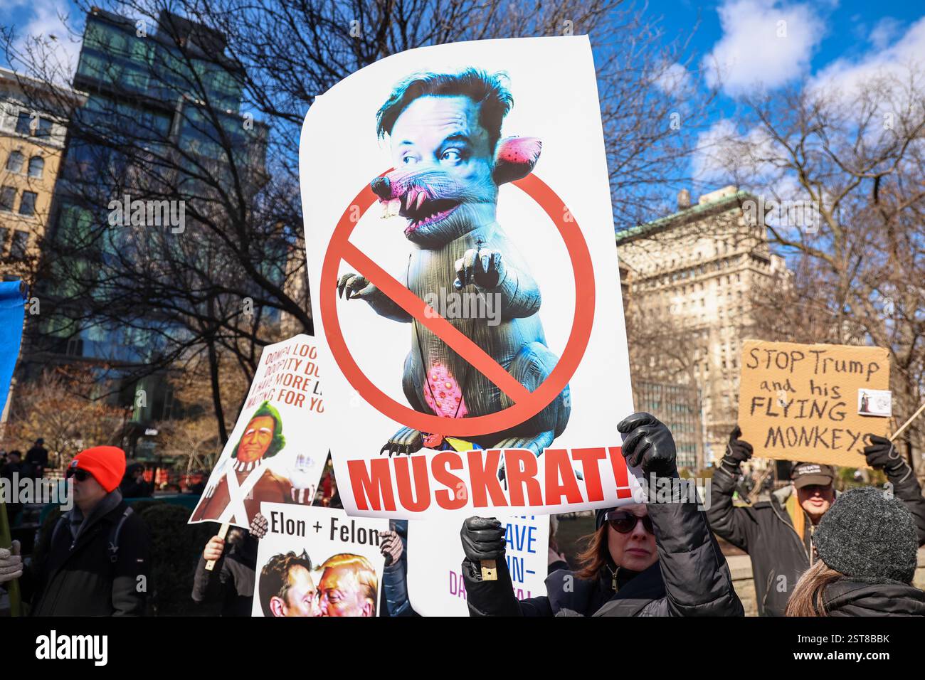 People hold up placards opposed to the policies of President Donald ...