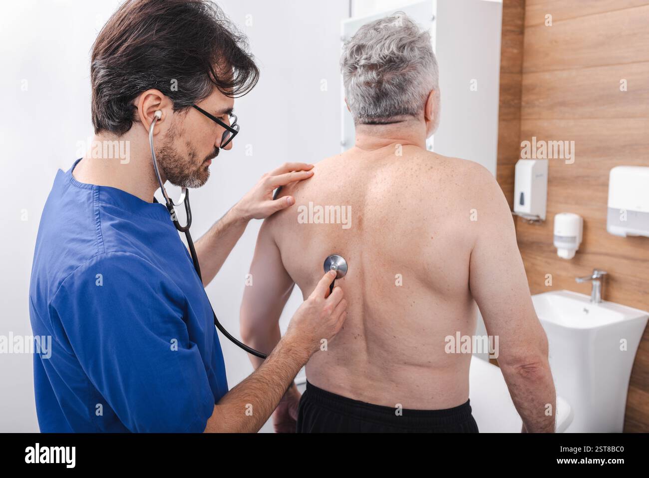 Doctor pulmonologist auscultation lungs for mature patient in a medical ...