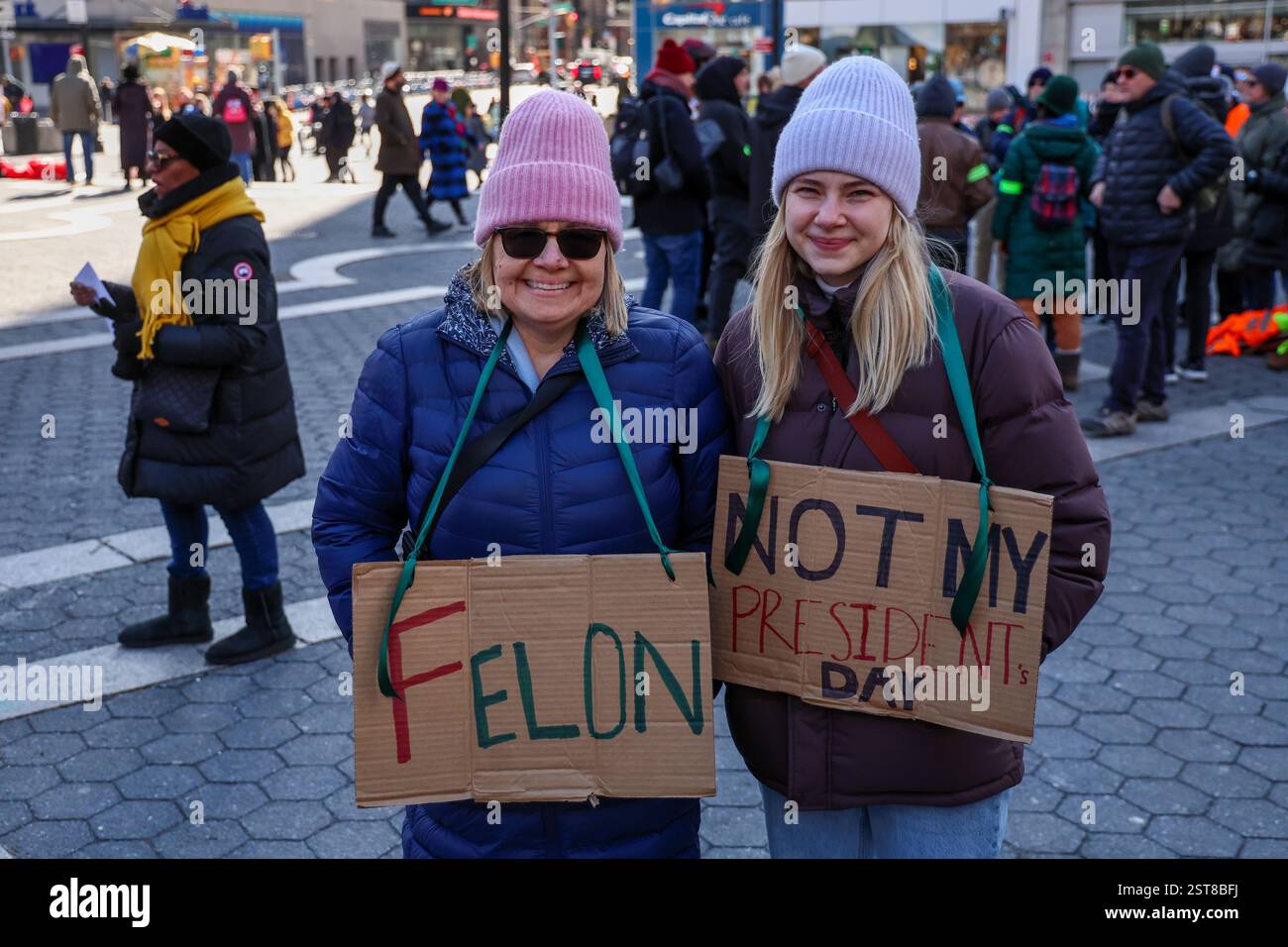 People hold up placards opposed to the policies of President Donald ...