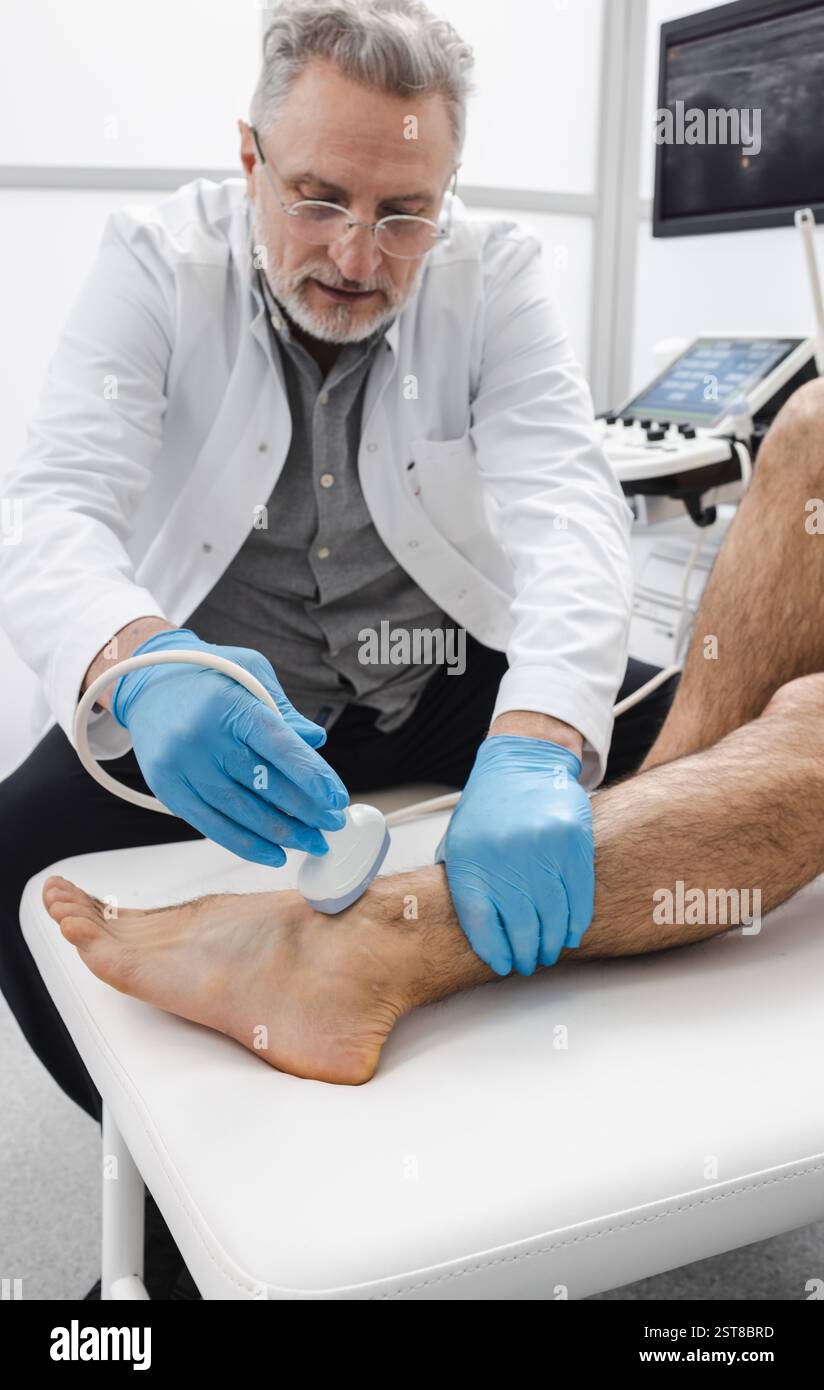 Ultrasonic of ankle joint. Sonographer checking patient ankle using ...