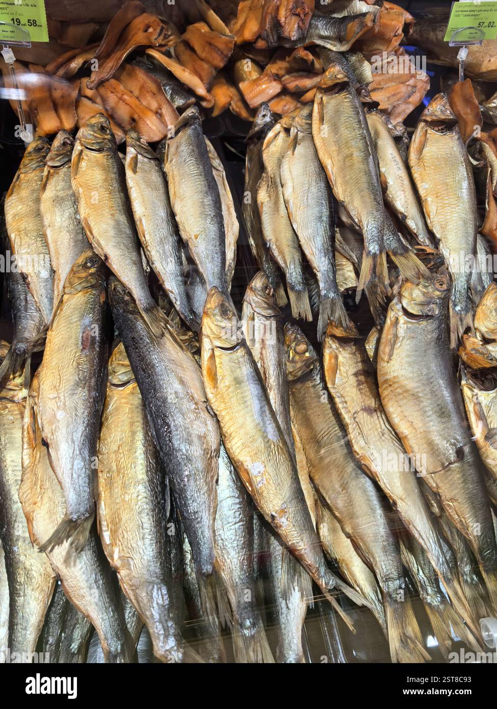 A lively market features a variety of smoked fish hanging from racks ...