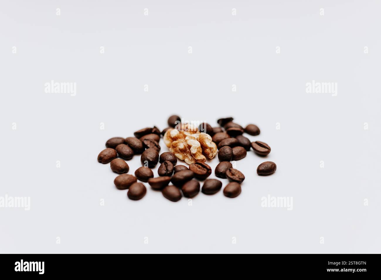 A beautiful combination of scattered nuts and coffee beans on a white ...