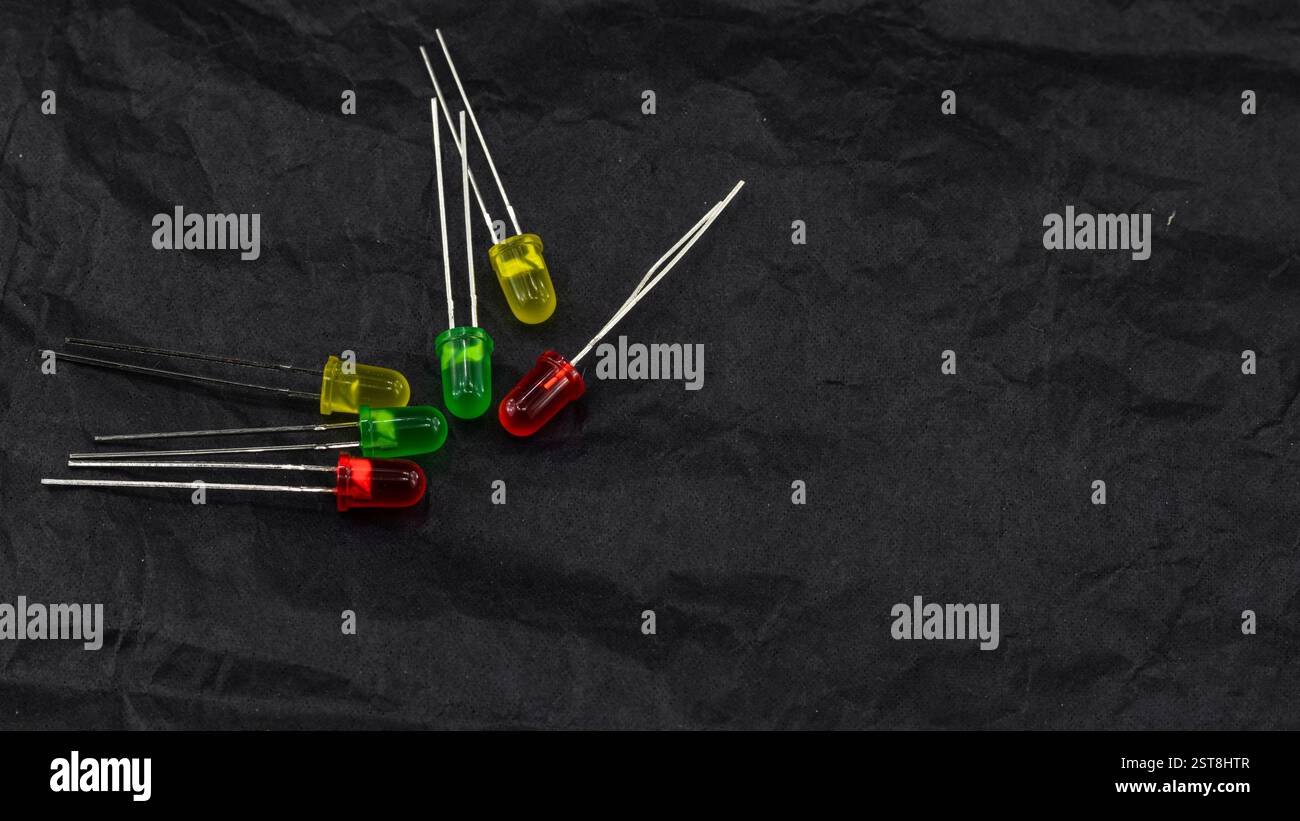 collection of red, green, and yellow LED diodes arranged on a dark ...