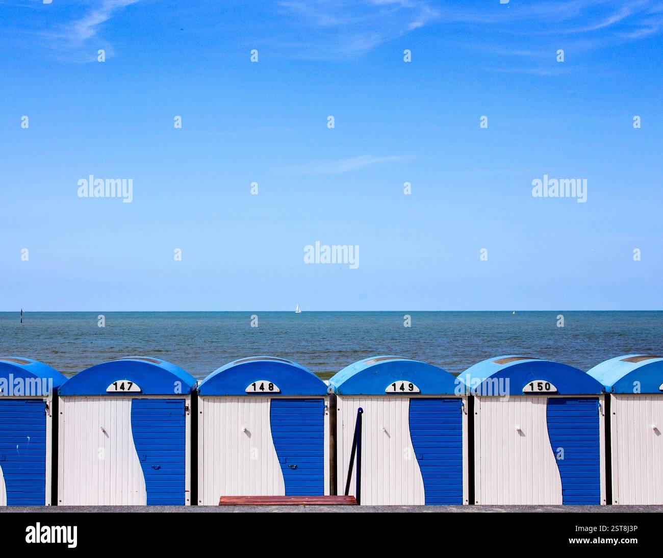 A row of charming graphic blue beach huts standing proudly along the ...