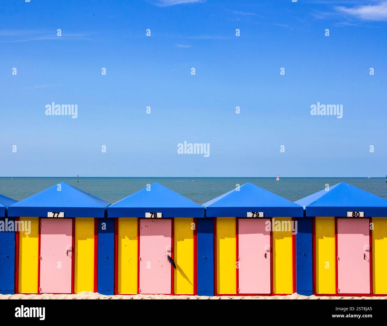 Coastal living at its finest—colorful beach huts standing in perfect ...