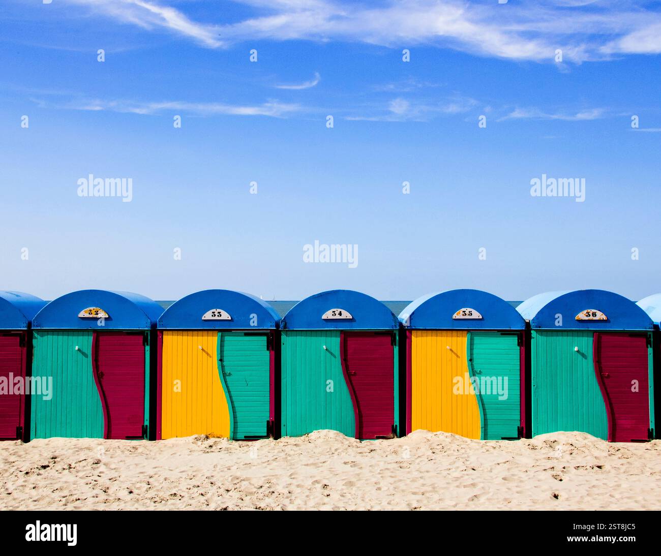 A captivating scene of seaside colorful graphic huts bathed in golden ...