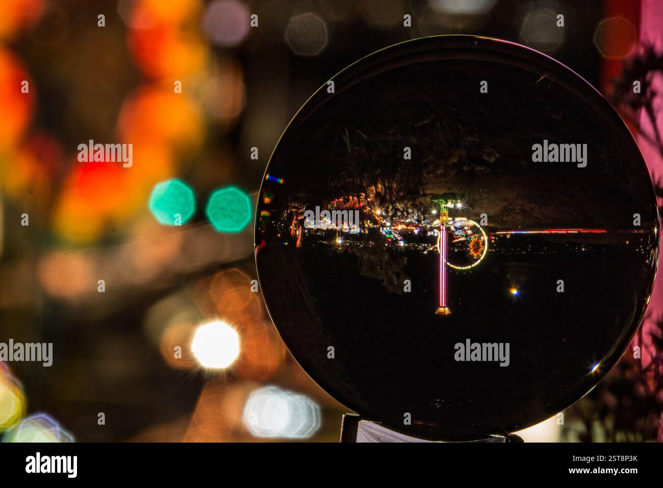 The colorful lights from a carnival midway viewed through a round ...