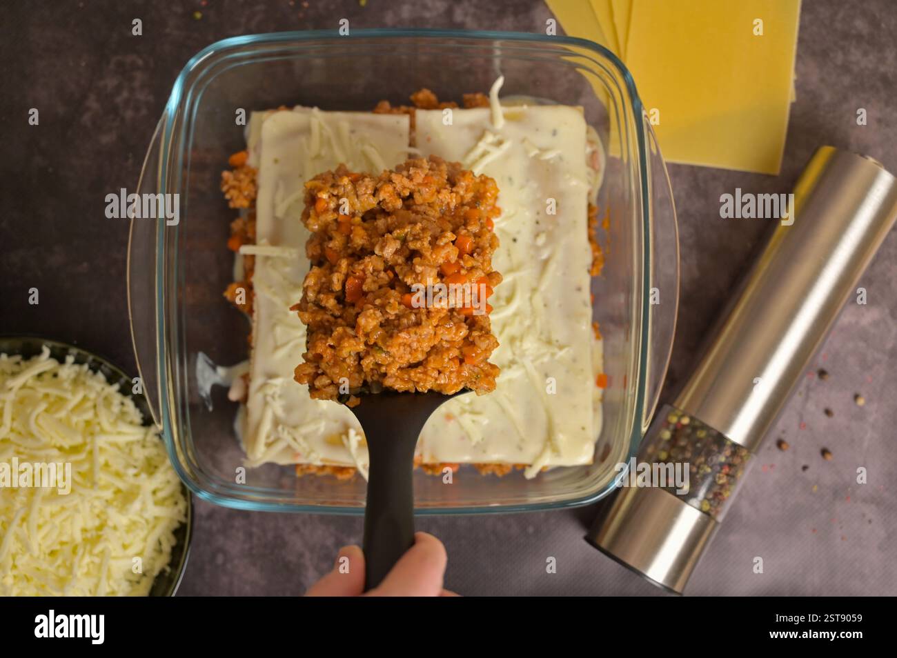 Top view. Homemade lasagna cooking preparation. Woman's hand use a ...