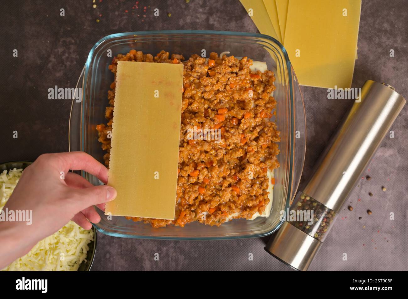 Top view. Homemade lasagna cooking preparation. Woman's hand putting ...