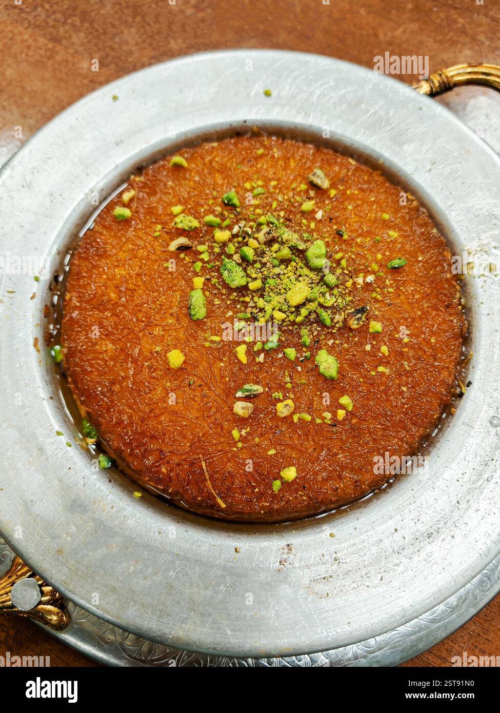 Turkish dessert kunefe, kunafa, kadayif with pistachio powder and cheese hot eaten sweet Stock ...