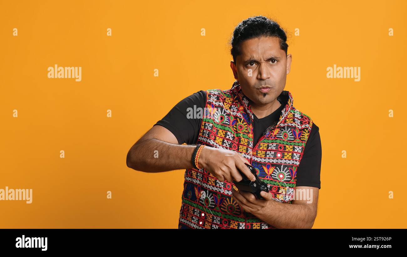 Cheerful man playing videogames with controller, studio background ...