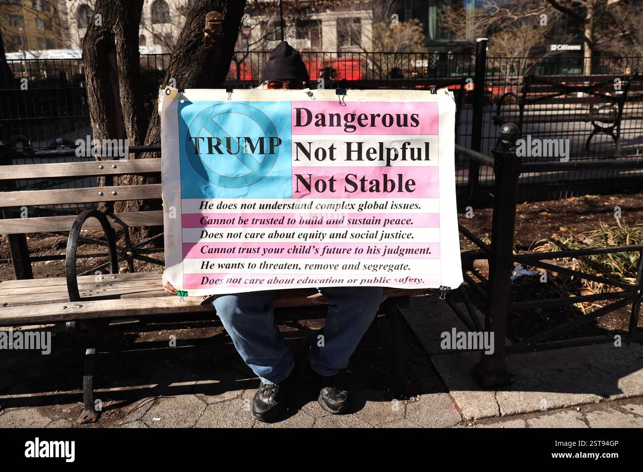 People hold up placards opposed to the policies of President Donald ...