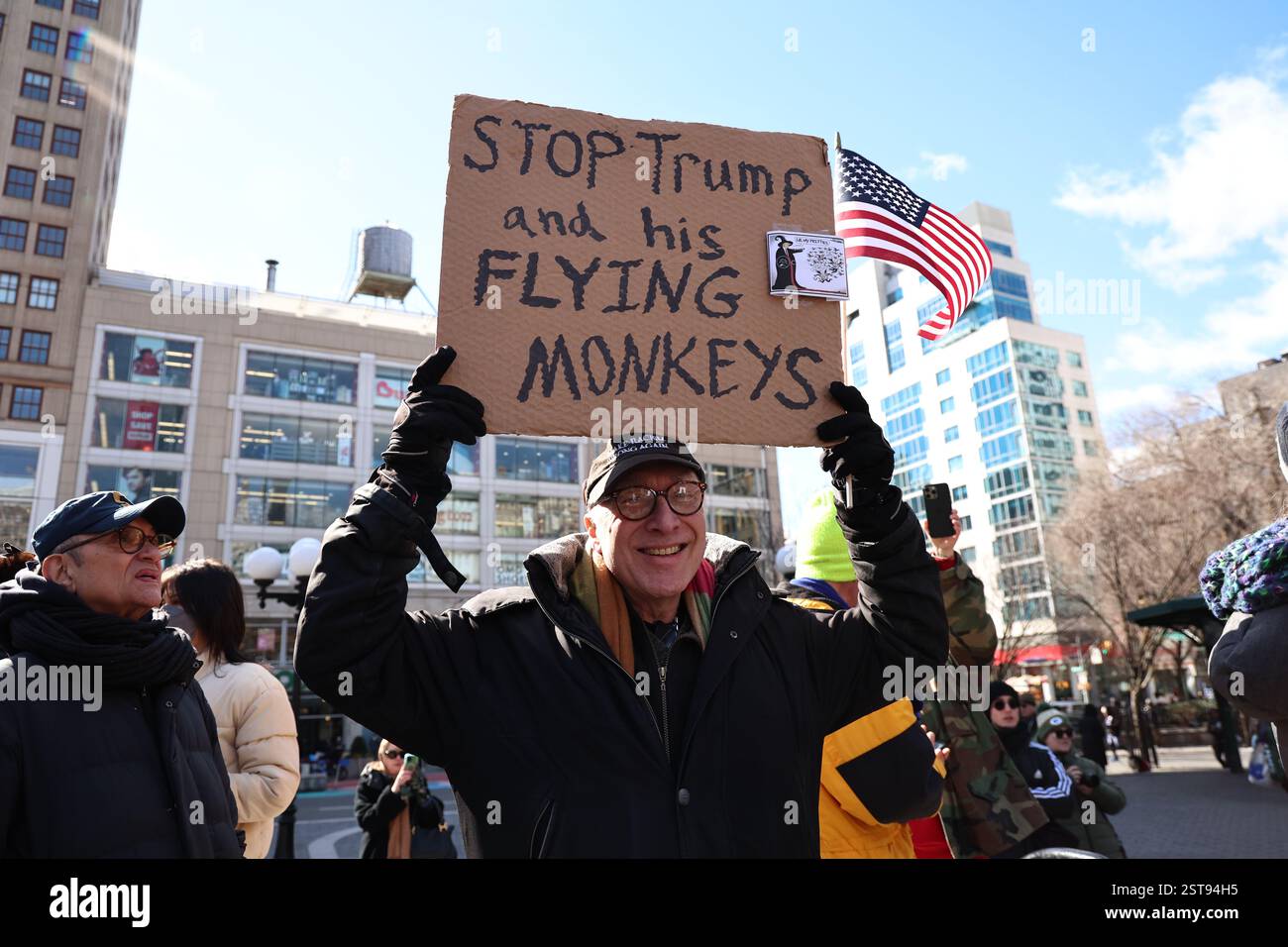 A man holds up a sign opposed to the policies of President Donald Trump ...