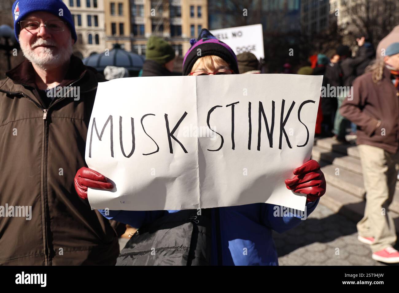 A woman holds up a sign opposed to Elon Musk’s involvement in the ...
