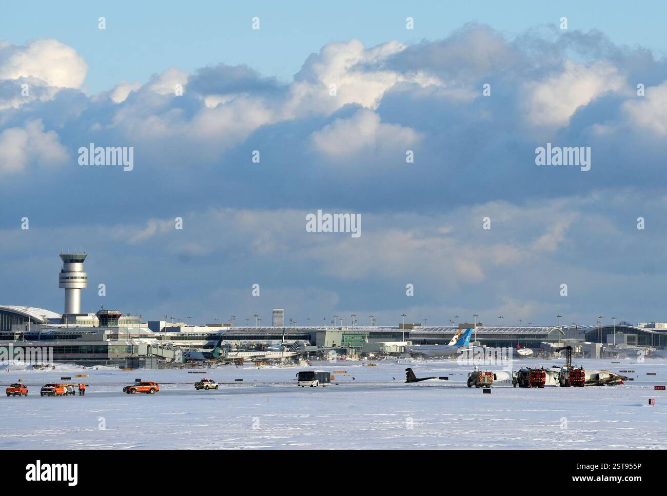 Crews work around an upside down Delta Air Lines plane, which was ...